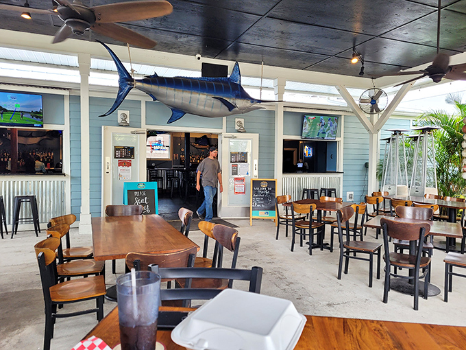 The outdoor seating area offers Florida sunshine with a side of people-watching. That marlin overhead seems to approve of your dining choices.
