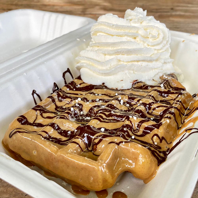 Chocolate and peanut butter drizzled over a golden waffle with whipped cream&mdash;basically childhood dreams in edible form.