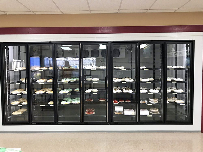 The refrigerated display—a gallery of edible masterpieces. Each shelf offers a different interpretation of pie perfection.