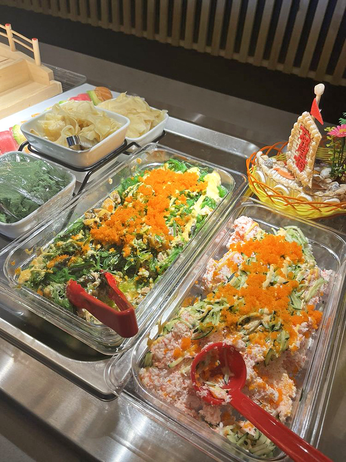 Salads topped with vibrant orange tobiko&mdash;proof that "healthy options" at a buffet don't have to be punishment.
