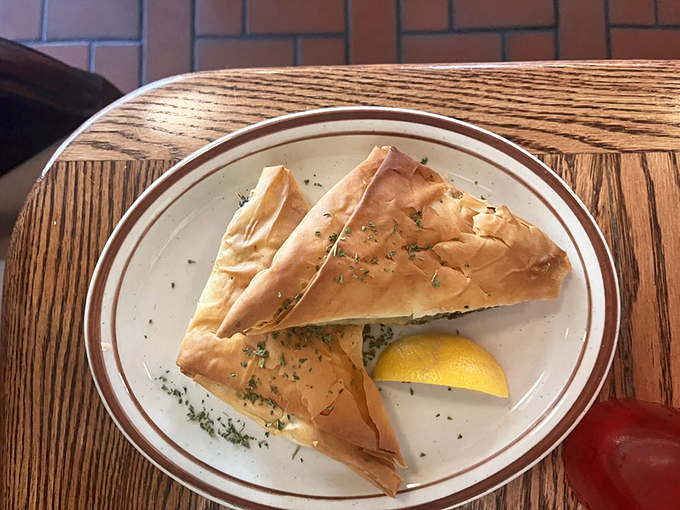 Spanakopita doesn't just flake&mdash;it shatters expectations. Buttery phyllo cradles savory spinach filling in this triangular treasure of Greek cuisine.