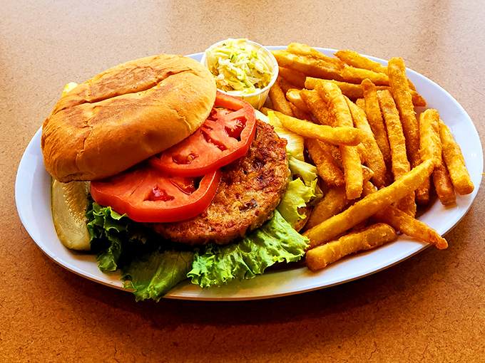 This isn't just a burger&mdash;it's architecture with lettuce. The golden fries standing at attention like they know they're part of something important.