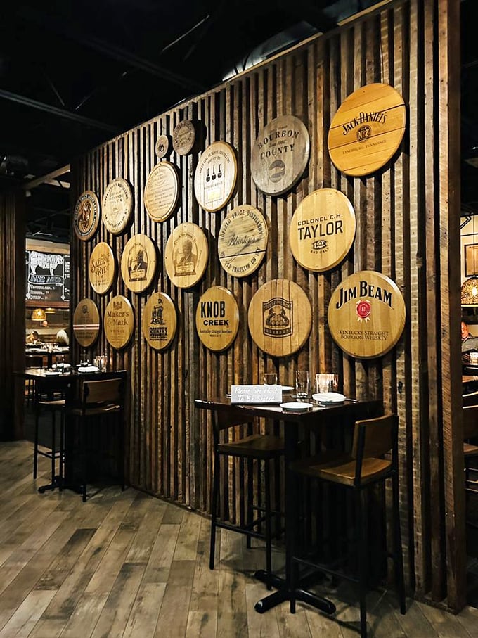 Barrel heads from bourbon royalty line the wooden walls, creating an atmosphere that whispers "relax, your steak is in good hands."