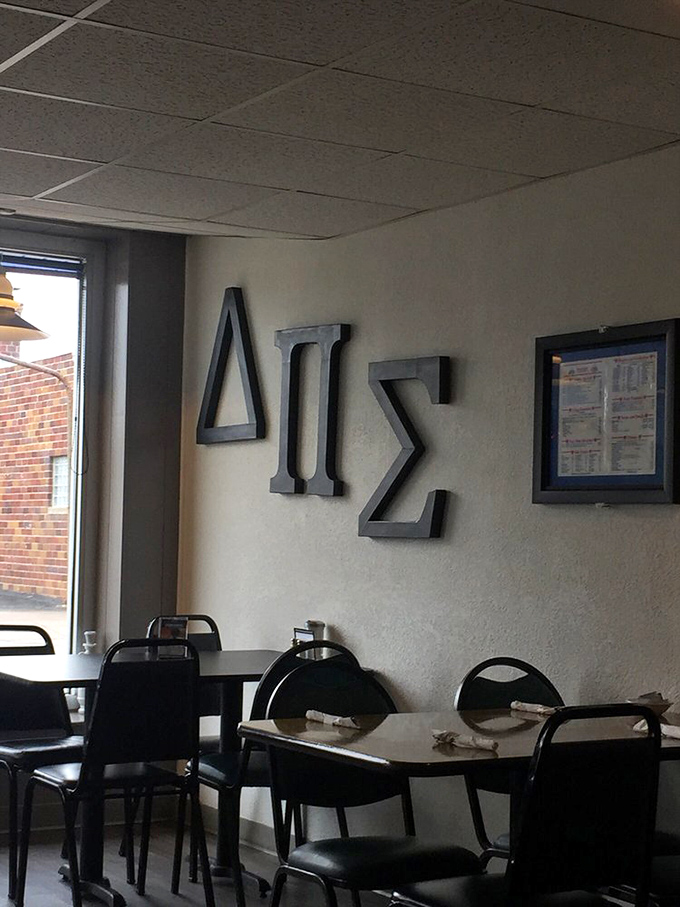 Greek letters on the wall remind you that you're not just eating food—you're participating in thousands of years of culinary tradition.