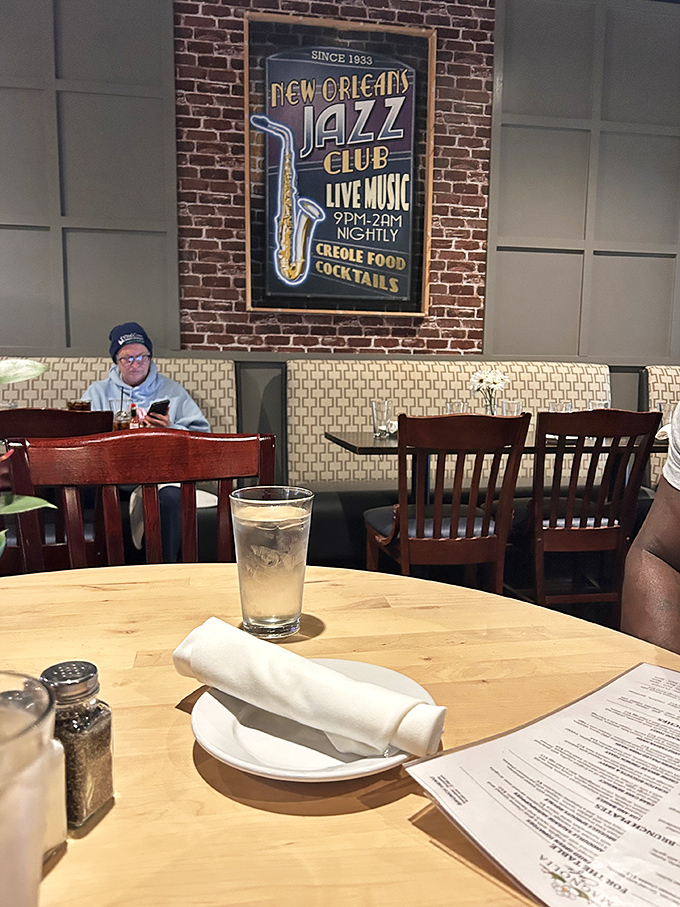 The New Orleans Jazz Club sign isn't just decoration&mdash;it's setting the mood. In the corner, a patron enjoys a quiet moment, proving good food and atmosphere create their own kind of music.