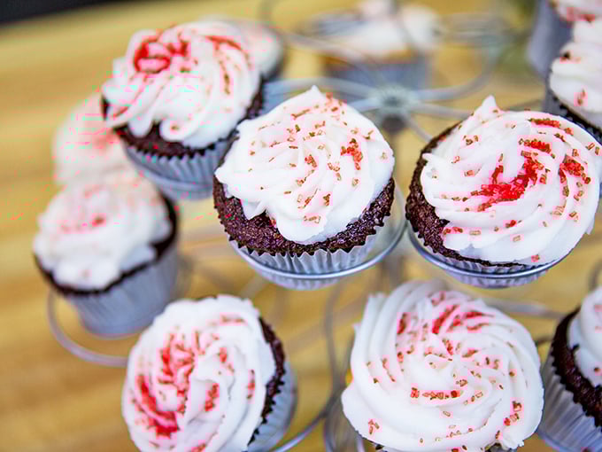 Red velvet cupcakes standing at attention like sweet little soldiers. Each one a perfect three-bite dessert symphony.