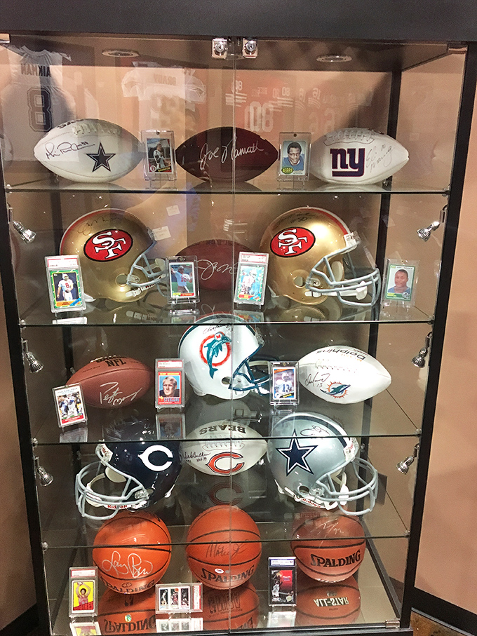 Sports memorabilia display case: where husbands linger while wives make actual furniture decisions, creating the illusion of a joint shopping experience.