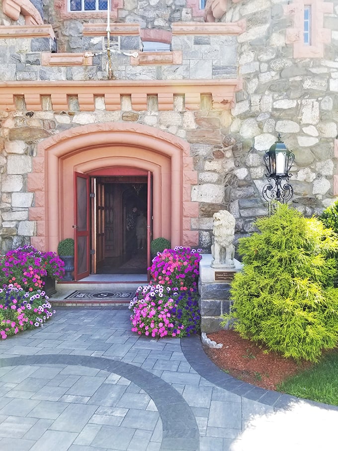 The castle's welcoming entrance blooms with vibrant flowers, proving that even stone fortresses appreciate a splash of color.
