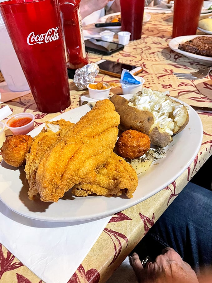 Golden-fried catfish that would make the Mississippi River proud, served alongside a loaded potato. Southern comfort on a plate, no translation needed.
