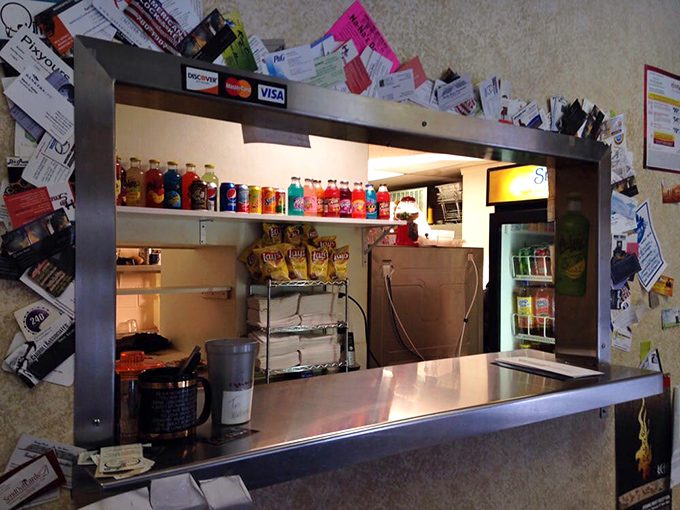 Business cards and credit card logos frame this window like a shrine&mdash;the humble gateway to barbecue enlightenment.