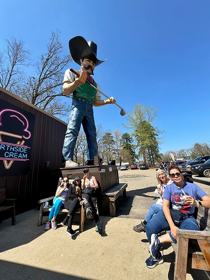 The statue watches over happy customers like a frozen dairy guardian angel, silently approving their excellent life choices.