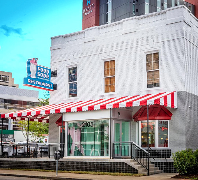 The classic white brick exterior stands proud against Nashville's modern skyline. That red-and-white awning has sheltered generations of hungry visitors.