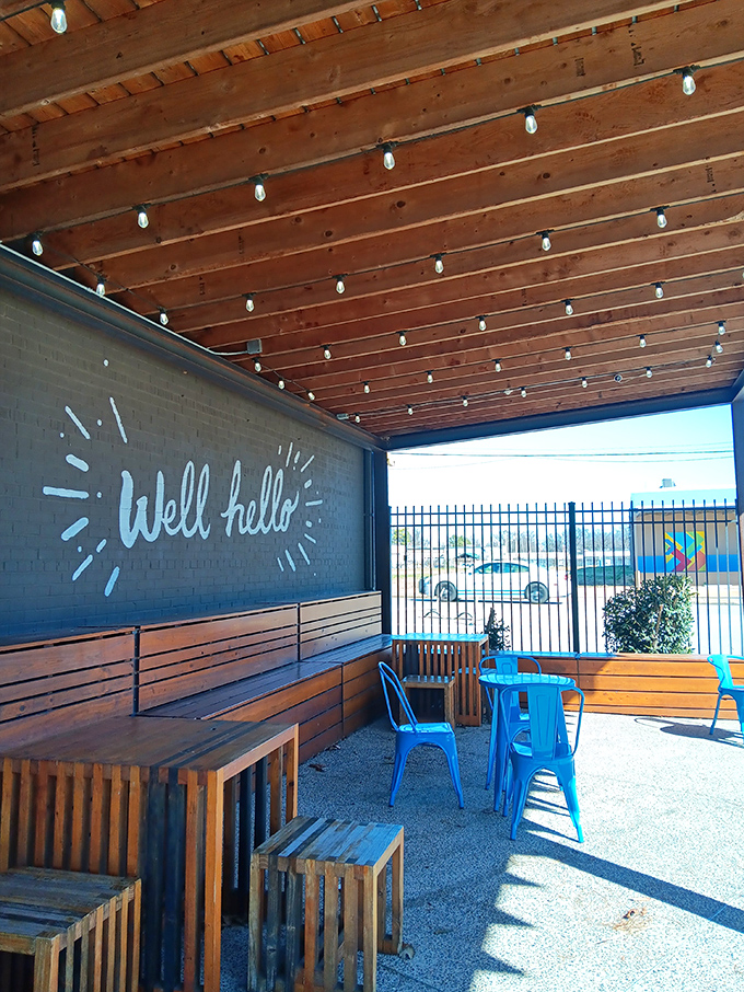 "Well hello" says the patio wall, offering a friendly greeting that perfectly captures the welcoming outdoor oasis where Memphis sunshine meets exceptional coffee.