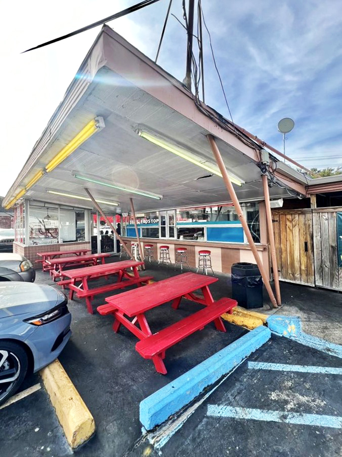 Those cherry-red picnic tables aren't just outdoor seating&mdash;they're front-row tickets to a New Orleans street theater with burgers as the main act.