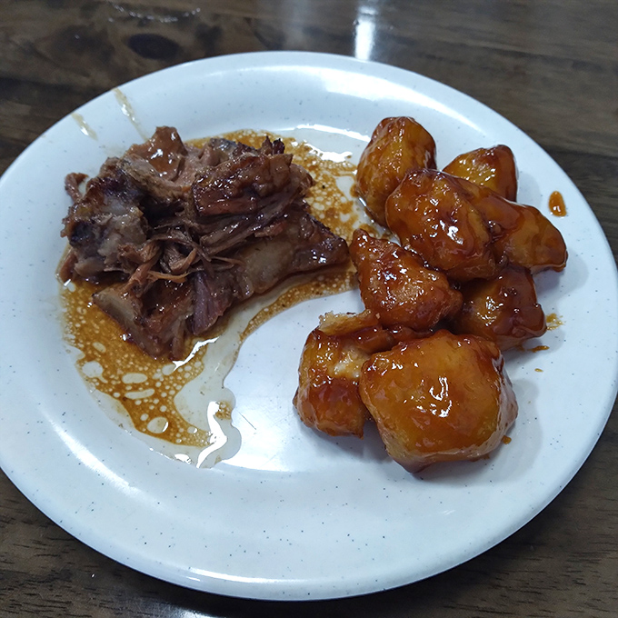Two saucy neighbors sharing a plate&mdash;tender pulled pork alongside glazed chicken chunks that practically beg for a scoop of fried rice.