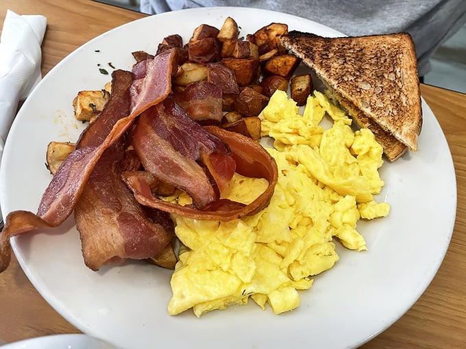 The breakfast trinity&mdash;golden eggs, crispy bacon, and home fries&mdash;executed with the precision of a morning symphony.