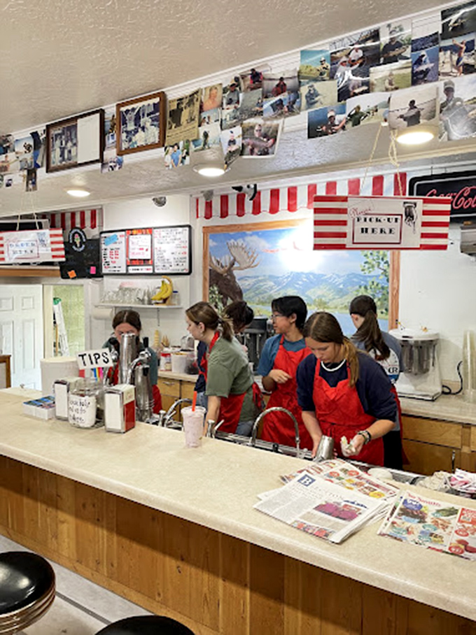 Young staff in red aprons work the counter with practiced efficiency. The next generation of huckleberry shake artisans in training.