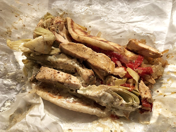 An artichoke chicken pita unwrapped reveals its treasures&mdash;seasoned chicken strips cozying up to artichoke hearts and roasted red peppers.