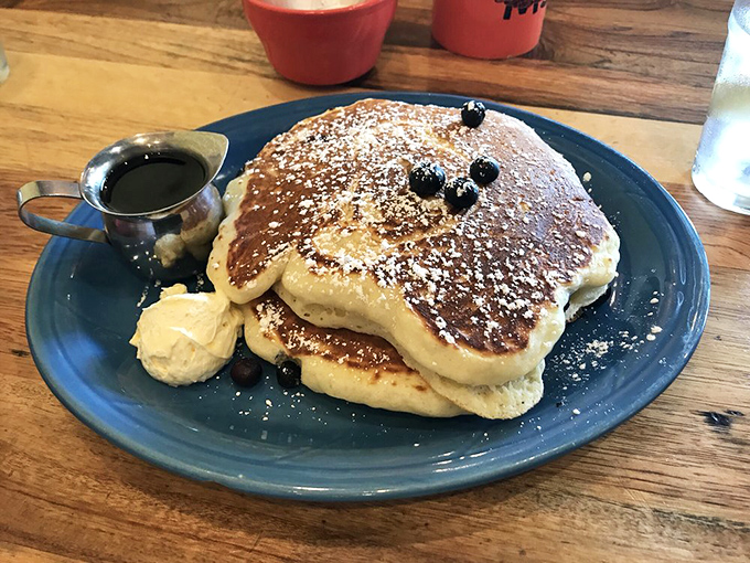 Pancakes so fluffy they could double as pillows, dusted with powdered sugar and topped with blueberries that burst with summer sweetness.