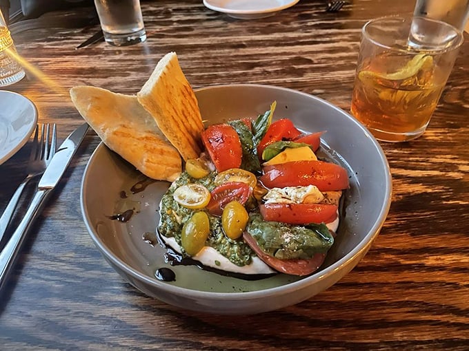 Fresh mozzarella and tomatoes having their best day ever, basking in olive oil and making a case for simplicity as the highest form of culinary art.