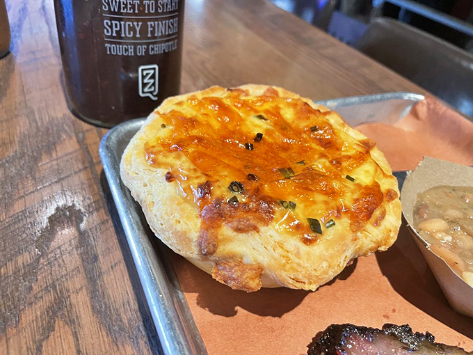 This isn't just cornbread&mdash;it's a golden disk of sunshine that's been kissed by fire and topped with what appears to be melted cheese and chives.