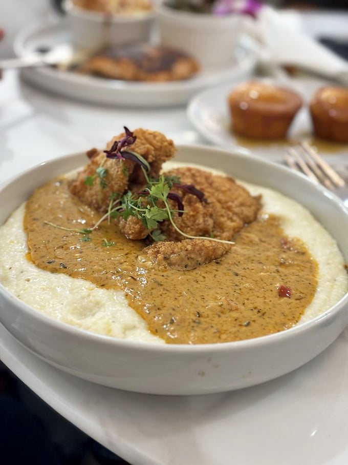 Catfish and grits—a Southern classic reimagined with crispy perfection and a sauce so good you'll consider drinking it directly.