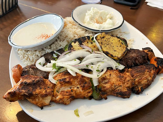 The holy trinity of Mediterranean meats. Chicken, lamb, and beef share the spotlight with grilled vegetables and rice&mdash;a plate that demands to be photographed.