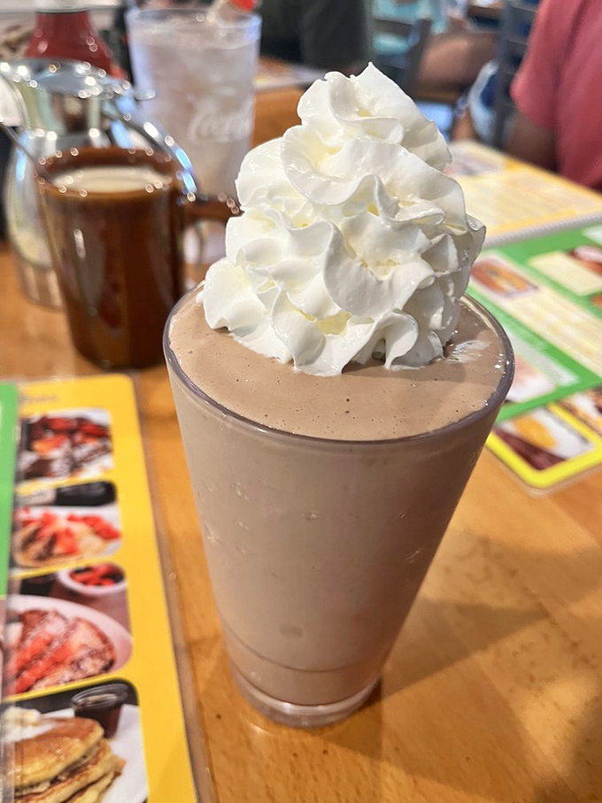 A milkshake with a mountain of whipped cream so tall it deserves its own ZIP code - dessert elevation at its finest.