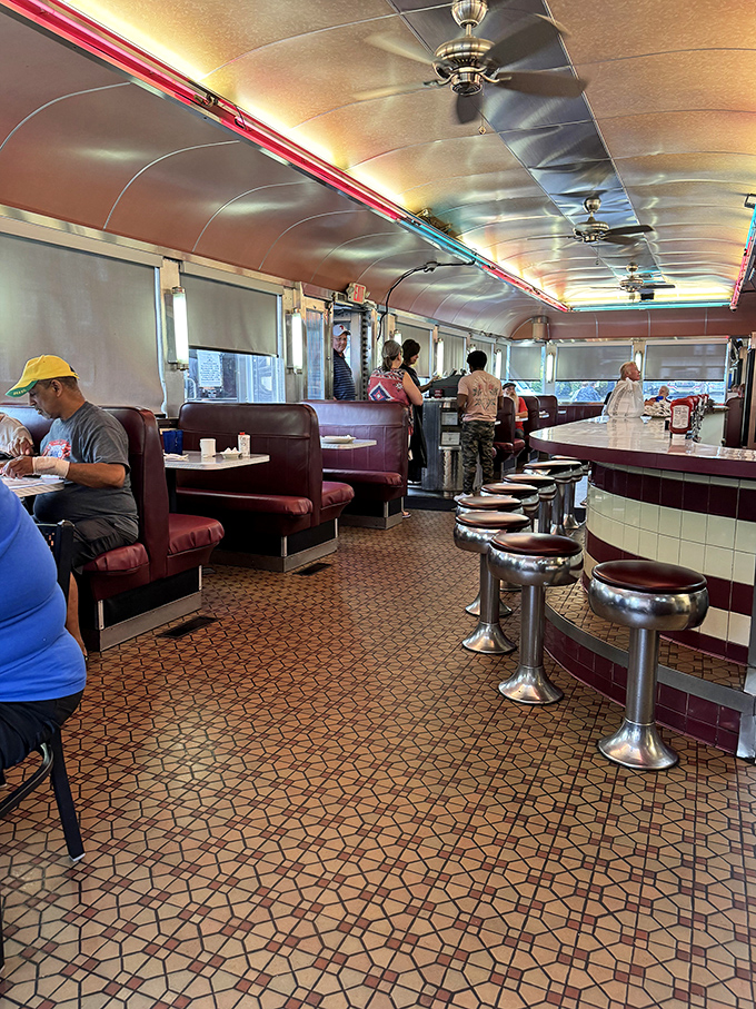 Classic diner geometry: the counter curves, the ceiling gleams, and hungry patrons line up for their turn at breakfast bliss. 