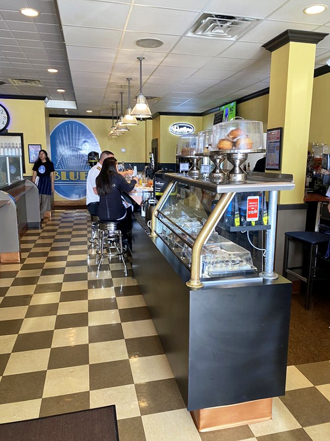 The classic black and white checkered floor meets sunny yellow walls—a diner aesthetic that says "good food happens here" before you even order.
