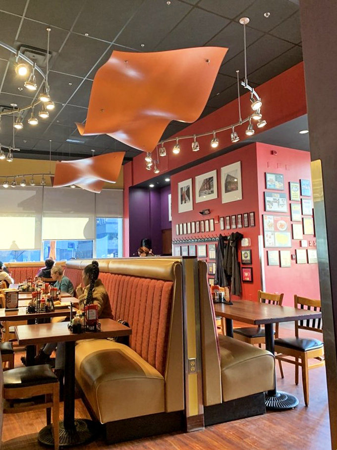 The curved orange ceiling fixtures float like breakfast UFOs, watching over diners making memories one bite at a time.