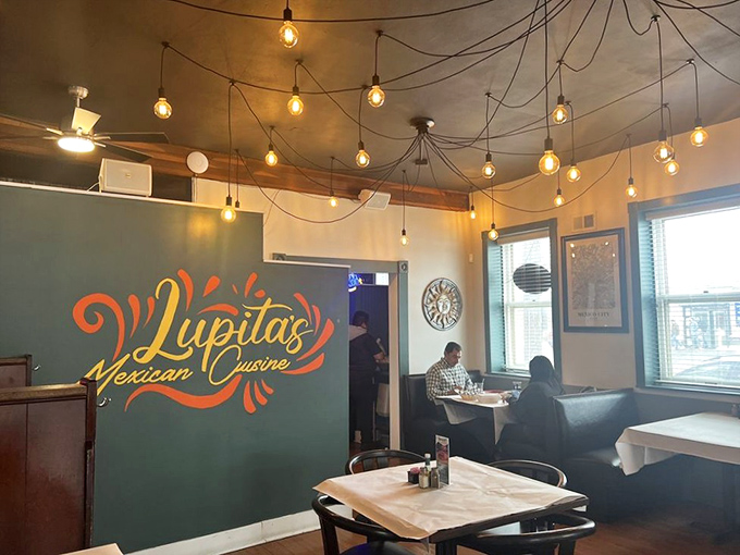 Modern lighting fixtures create a warm glow over simple tables where food takes center stage. That lone diner isn't eating alone&mdash;he's having a love affair with his meal.