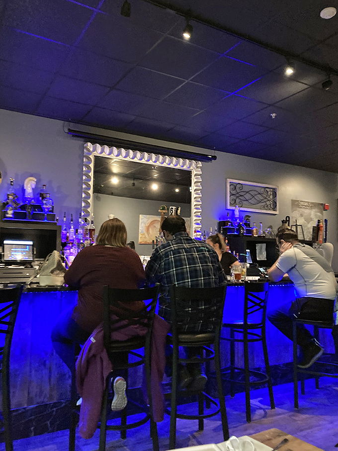 The blue-lit bar creates an atmosphere where strangers become friends and friends become family&mdash;just like in the tavernas of Greece.