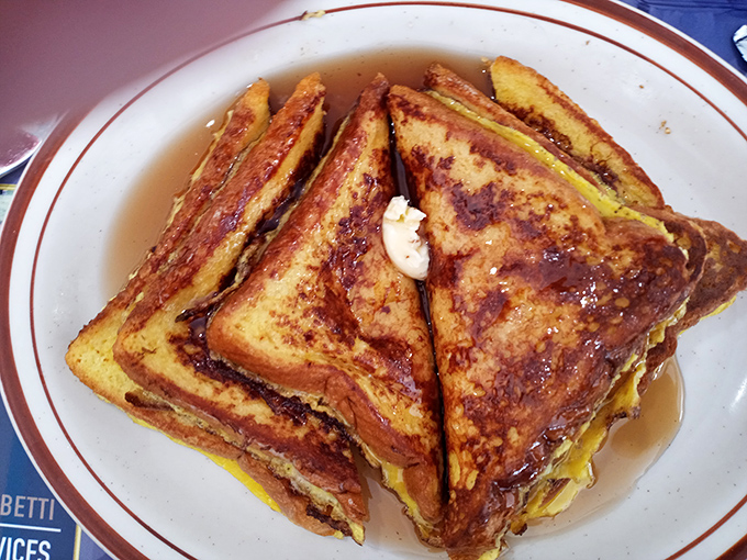 French toast swimming in maple syrup, looking like it just won the breakfast lottery. Each triangle is a golden-brown promise of sweet satisfaction. 