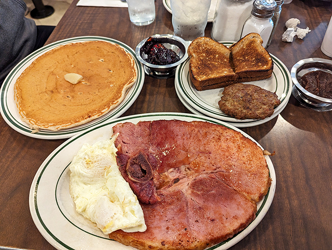 The breakfast trifecta&mdash;a golden pancake, perfectly cooked ham, and eggs that would make a chicken proud. This isn't a meal; it's a morning masterpiece.