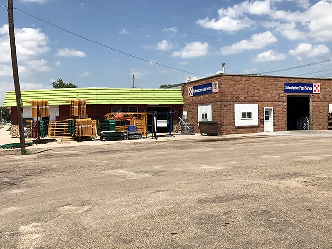 The bright lime-green awning of Kohmetscher Feed Services stands out against the Nebraska sky&mdash;agricultural necessity meets small-town visibility.