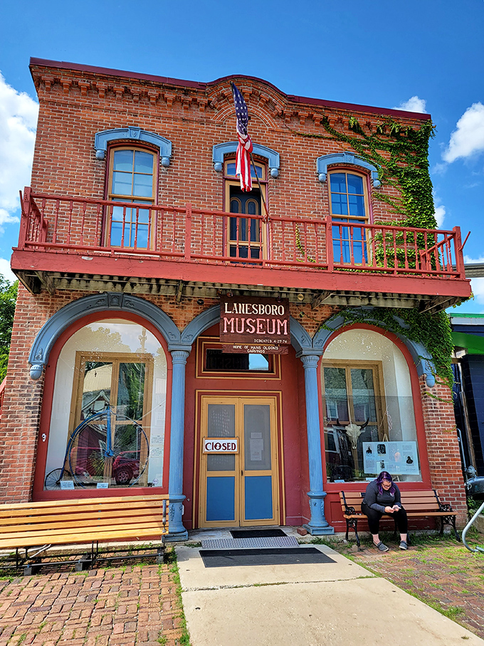 The Lanesboro Museum stands as the town's memory keeper, its brick façade and welcoming bench inviting visitors to sit and contemplate stories from another era.