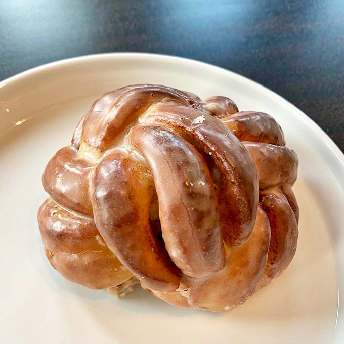 This cinnamon roll looks like it got tangled up with itself from sheer excitement. The glaze catches light like morning dew on pastry.