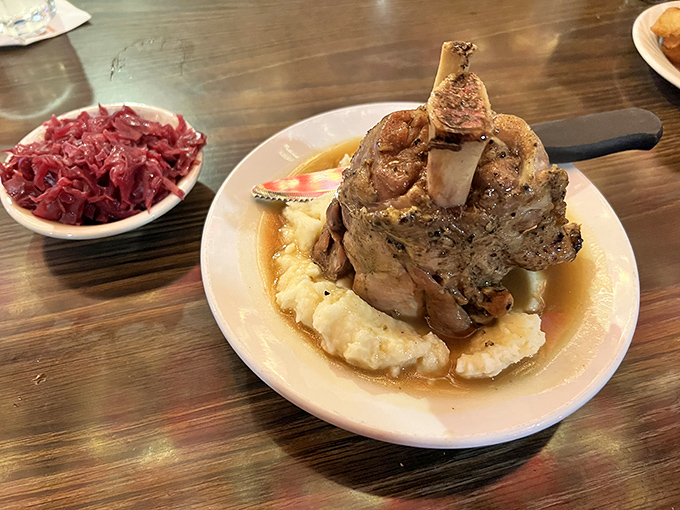 This isn't just a pork shank&mdash;it's a monument to meat, proudly standing in a pool of gravy with red cabbage as its loyal sidekick. Fork and knife required.