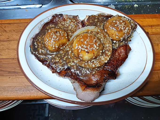 This isn't just a pork chop&mdash;it's a masterclass in meat preparation topped with what appears to be the world's most tempting mushroom sauce.