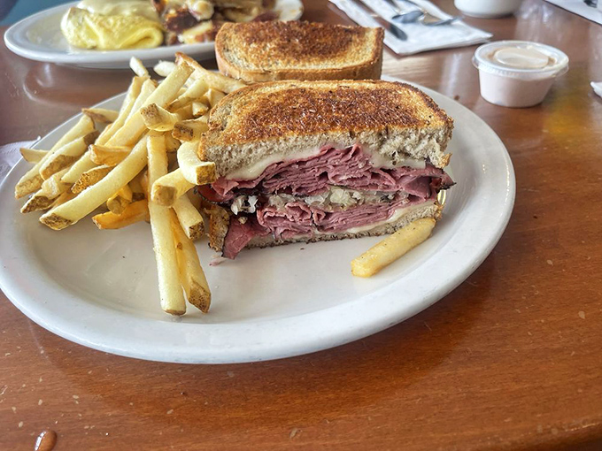The Reuben sandwich that launched a thousand napkins &ndash; towering with corned beef and sauerkraut, flanked by golden fries standing at attention.