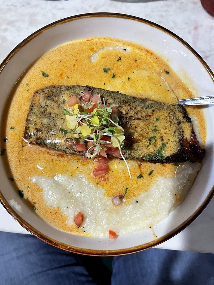Salmon and grits swimming in a sunset-colored sauce that makes you wonder why you ever settled for plain old fish and rice.