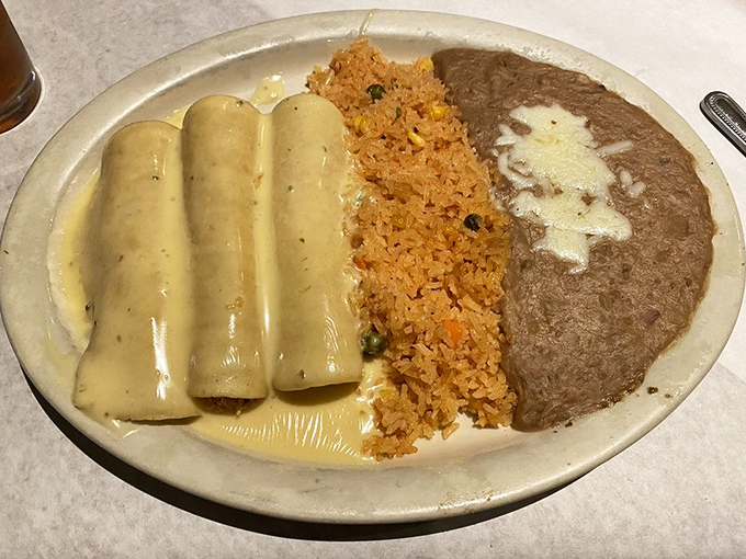 These enchiladas aren't just swimming in sauce&mdash;they're doing the backstroke in a pool of creamy deliciousness alongside rice and beans.