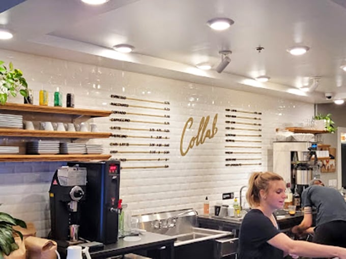 Behind the counter where coffee dreams come true. The gold "Collab" sign isn't just decor&mdash;it's a promise of craftsmanship in every cup.