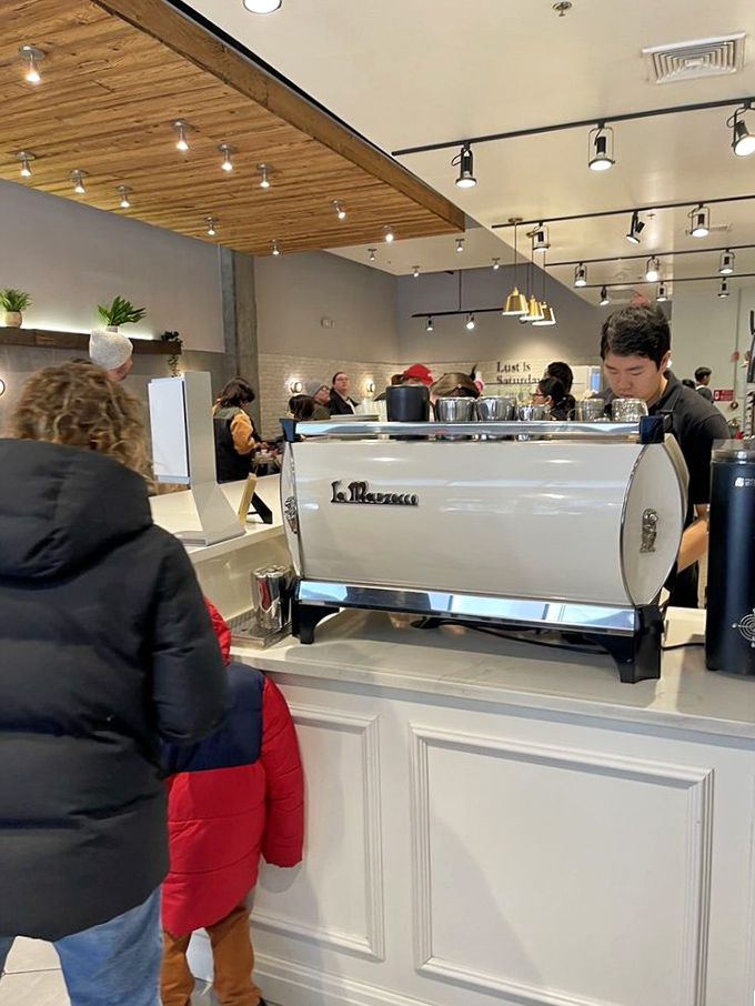 La Marzocco espresso machine stands ready while baristas work their magic—the unsung heroes of your morning transformation.