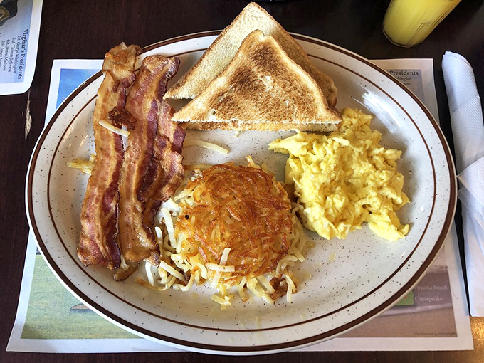 The breakfast trinity: perfectly scrambled eggs, crispy bacon, and golden hash browns. Add toast and you've got the four horsemen of satisfaction.