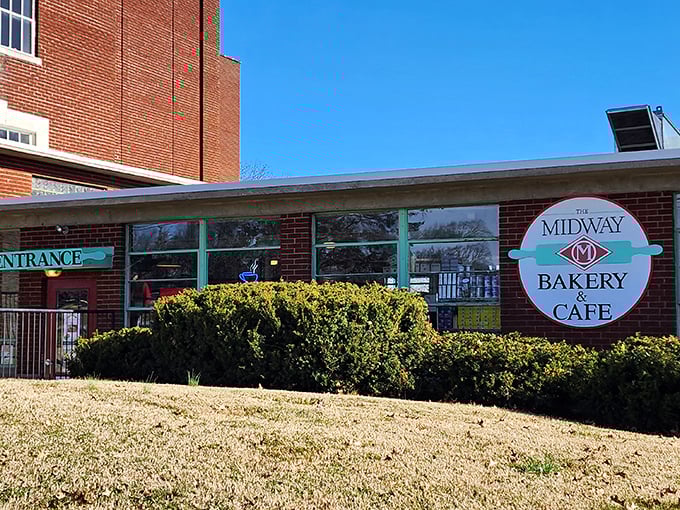 The Midway Bakery & Cafe's cheerful sign promises sweet salvation. Behind those windows lie pastries worth every single calorie.