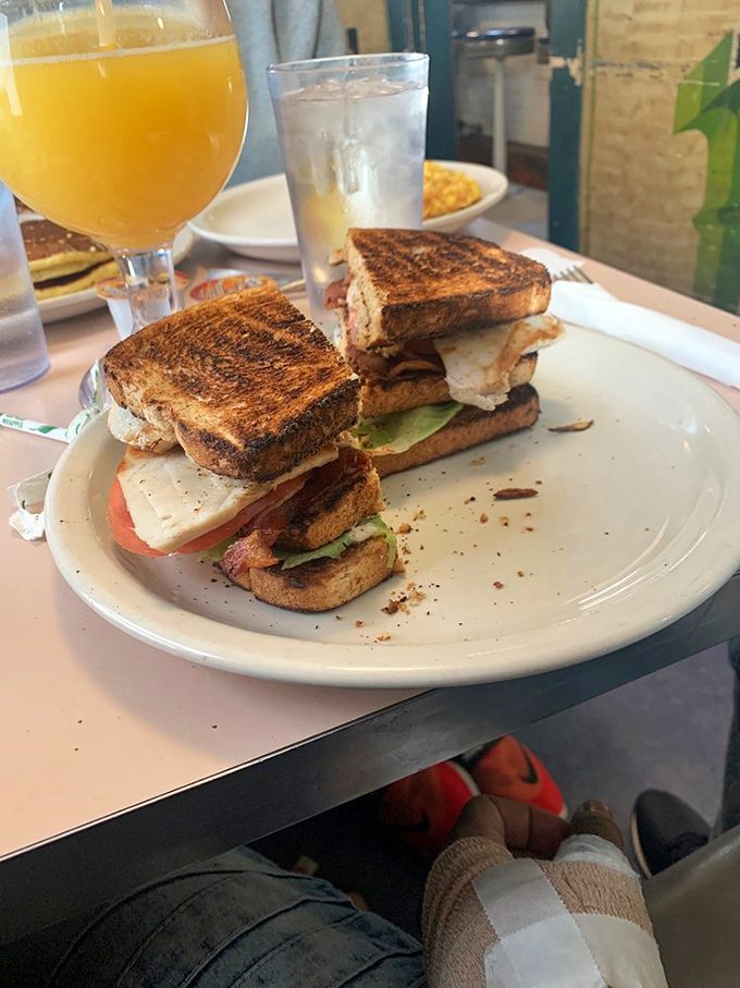 A club sandwich built like a skyscraper of deliciousness. The perfectly toasted bread is just showing off at this point, and we're here for it.