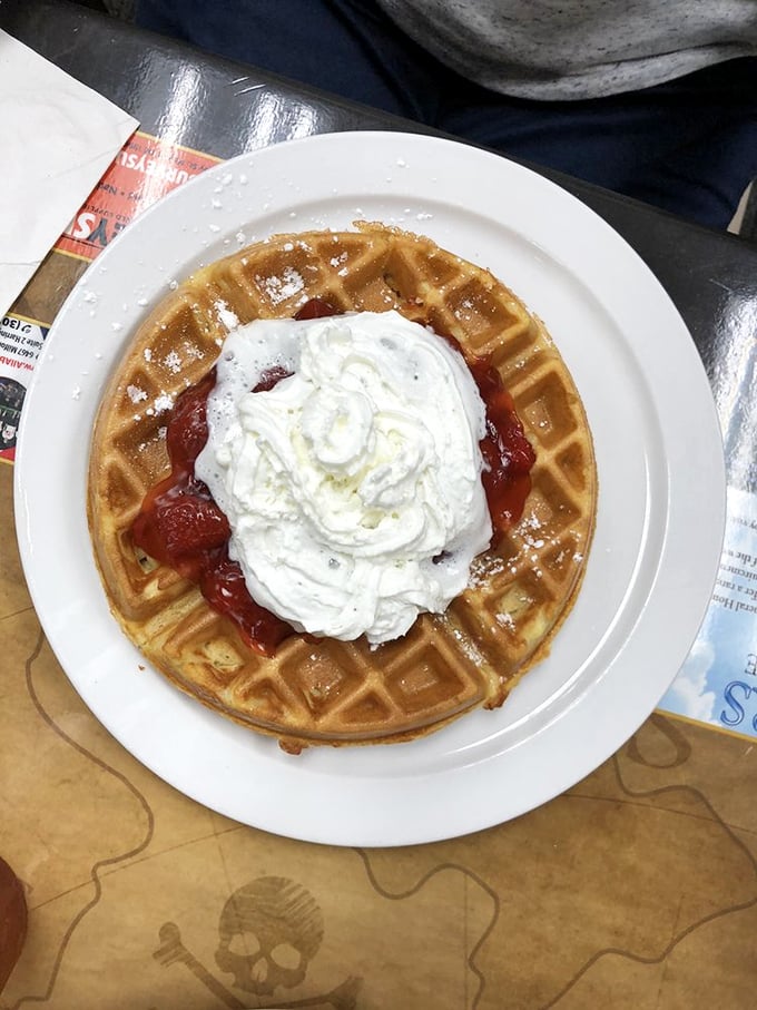 A waffle throne crowned with strawberry jewels and a cloud of whipped cream. Breakfast or dessert? The answer is yes.