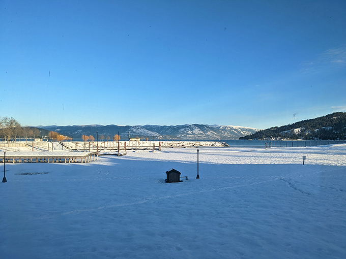 Winter transforms Sandpoint's waterfront into a serene wonderland where coffee somehow tastes better while gazing at snow-capped mountains.